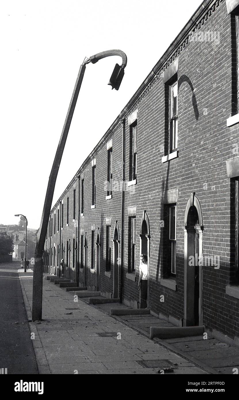 1960s, historical, outside in street of victorian terraced cottages, a ...