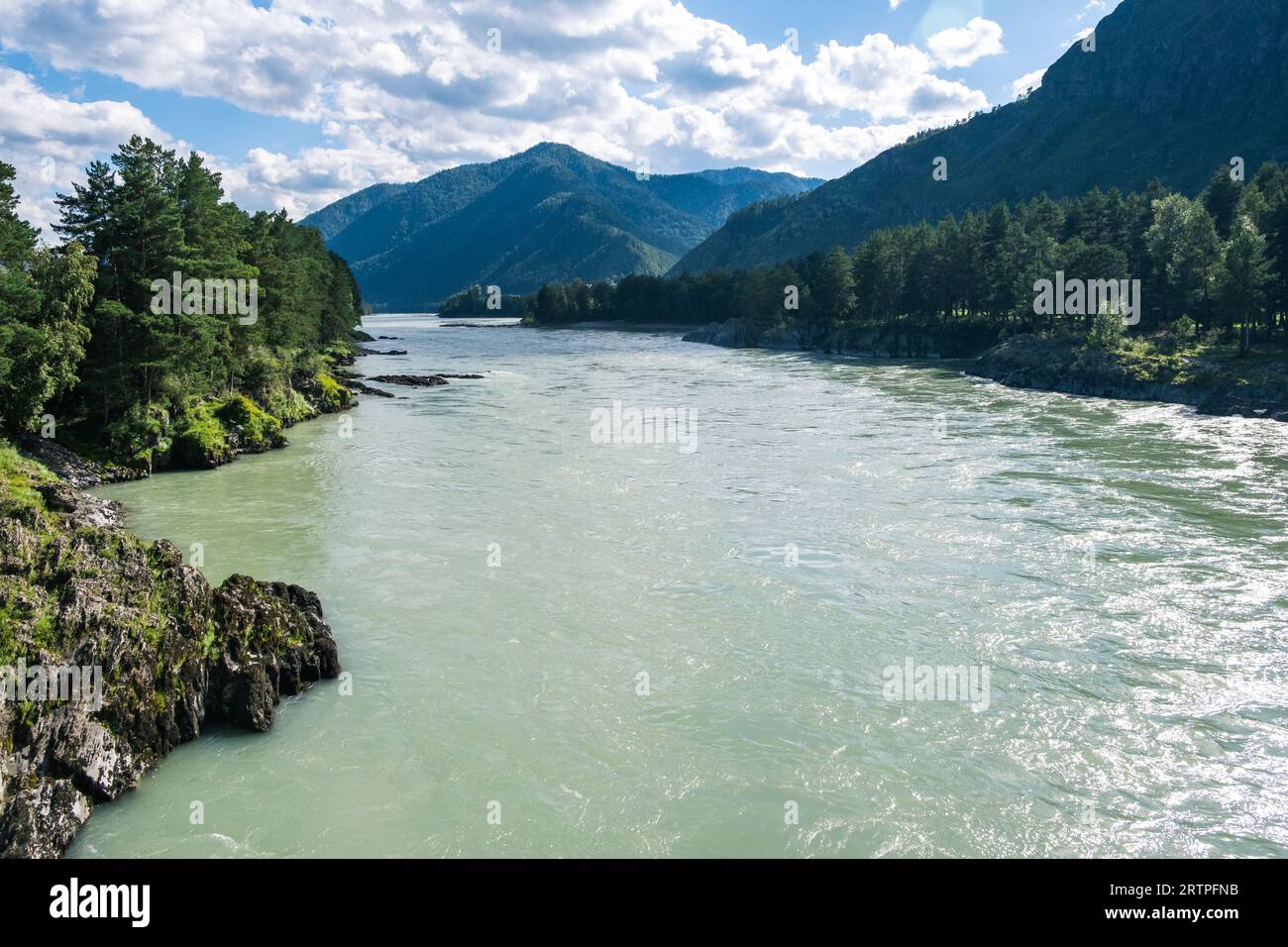 A wide, full-flowing mountain river with a fast current Stock Photo - Alamy