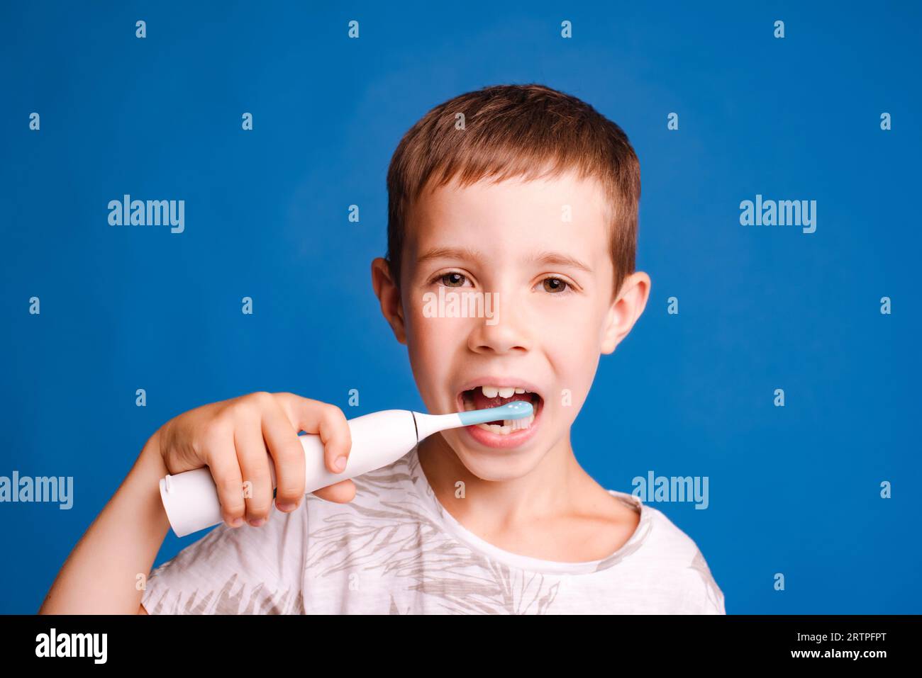 headshot child boy holding toothbrush and brush teeth with electric ...