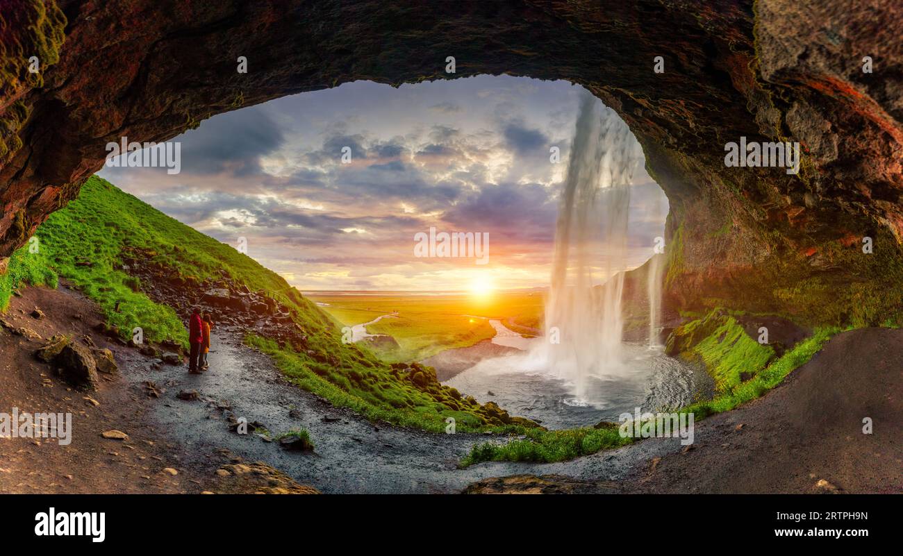 Majestic natural cave with sunset over Seljalandsfoss waterfall flowing ...