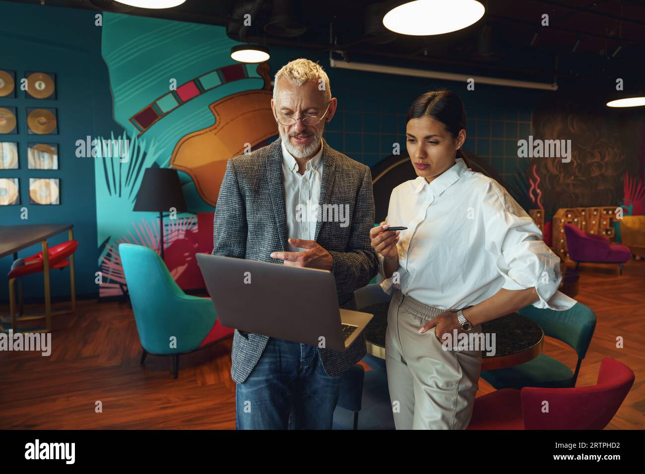 Two diverse colleagues discussing daily plans in office using laptop ...