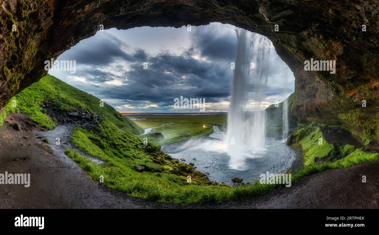 Majestic natural cave with Seljalandsfoss waterfall flowing and lush ...