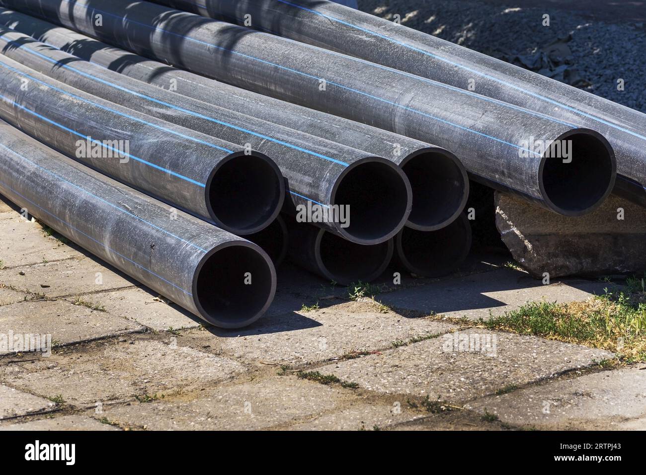 Plastic main black pipes. A heap of polyethylene pipes for a water ...