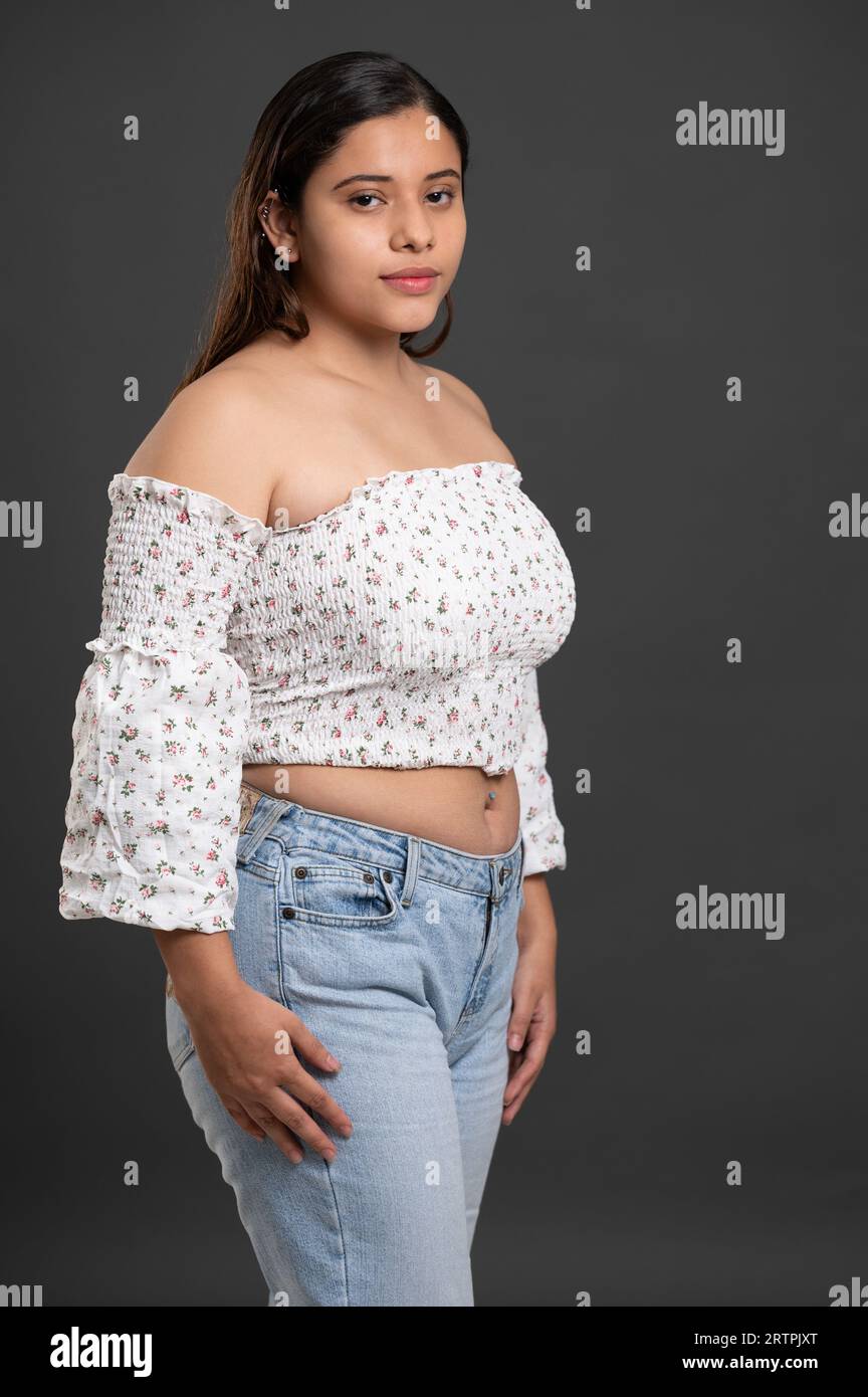 Portrait of young plus size hispanic model on grey studio background ...