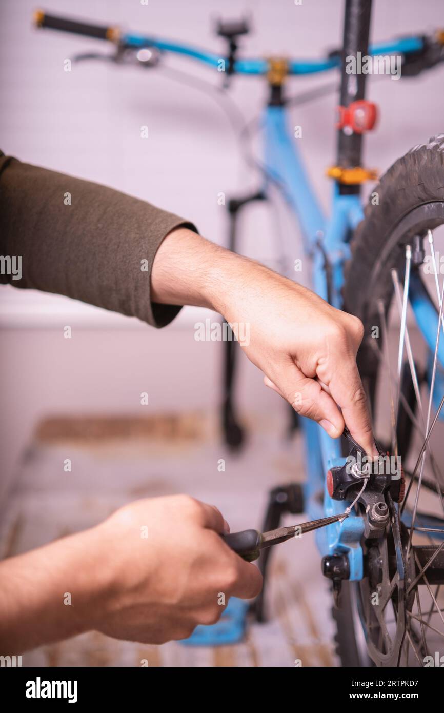 Hand installing a rear break in a blue bike Stock Photo - Alamy