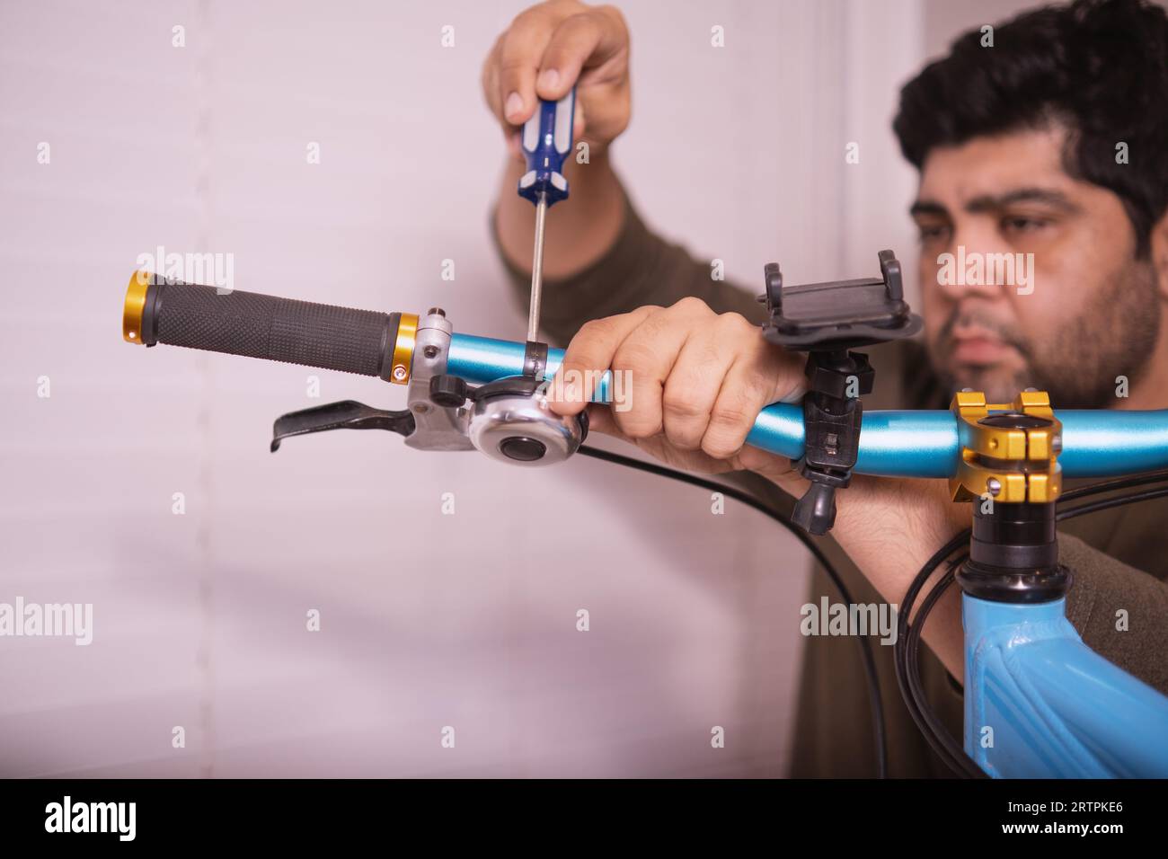 Man mounting a bell in a blue bike Stock Photo - Alamy