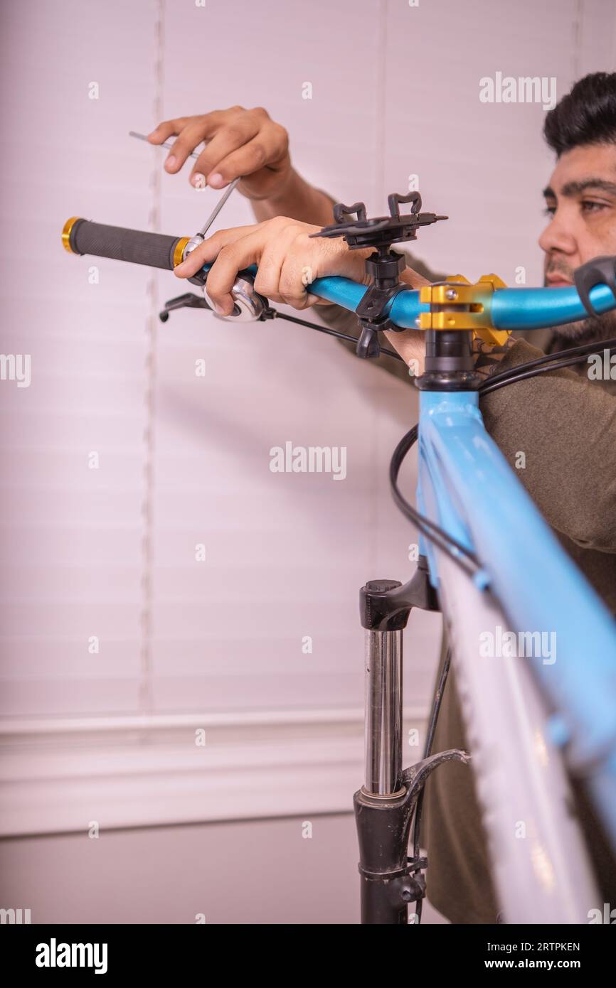 Man mounting a bell in a blue bike Stock Photo - Alamy