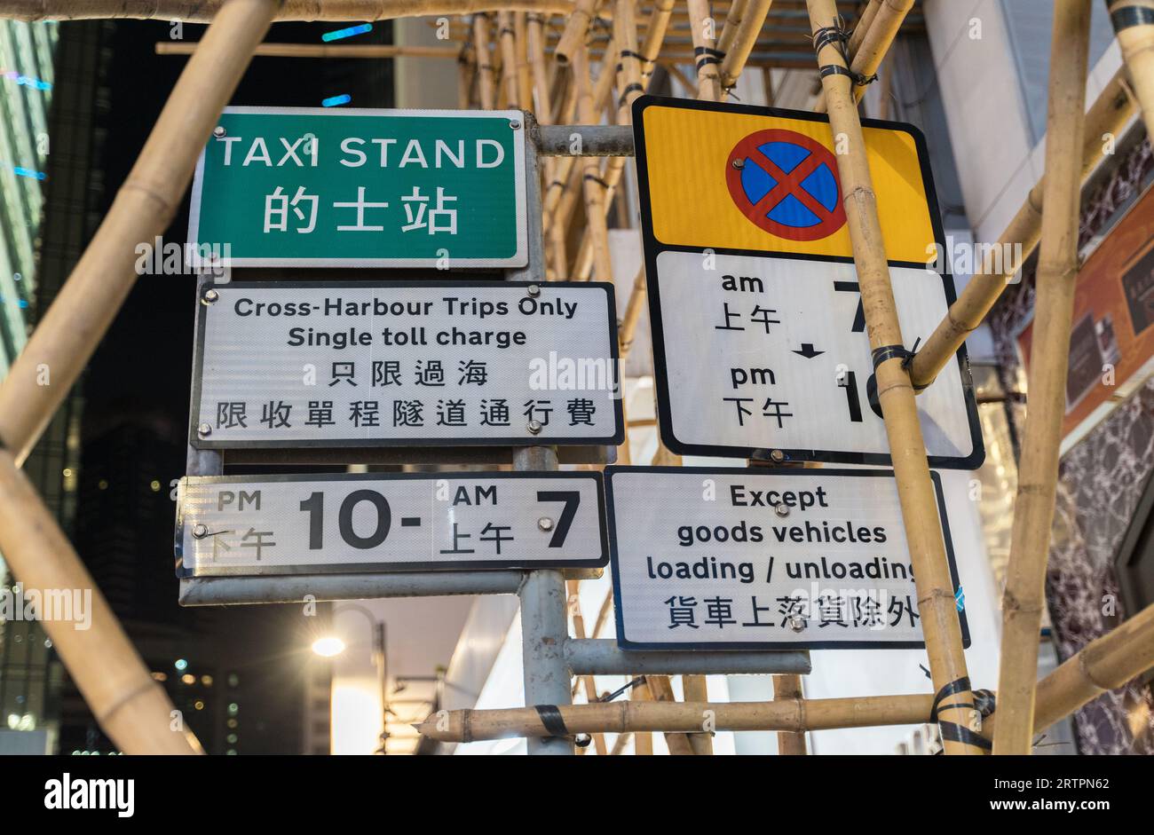 Taxi stand and other street traffic signs surrounded by bamboo ...