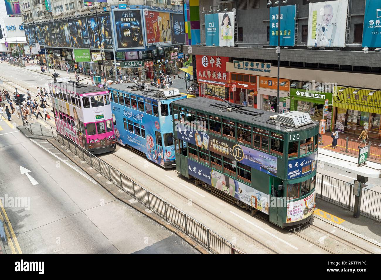 Old Hong Kong trams in the centre to the road in Causeway Bay on a ...