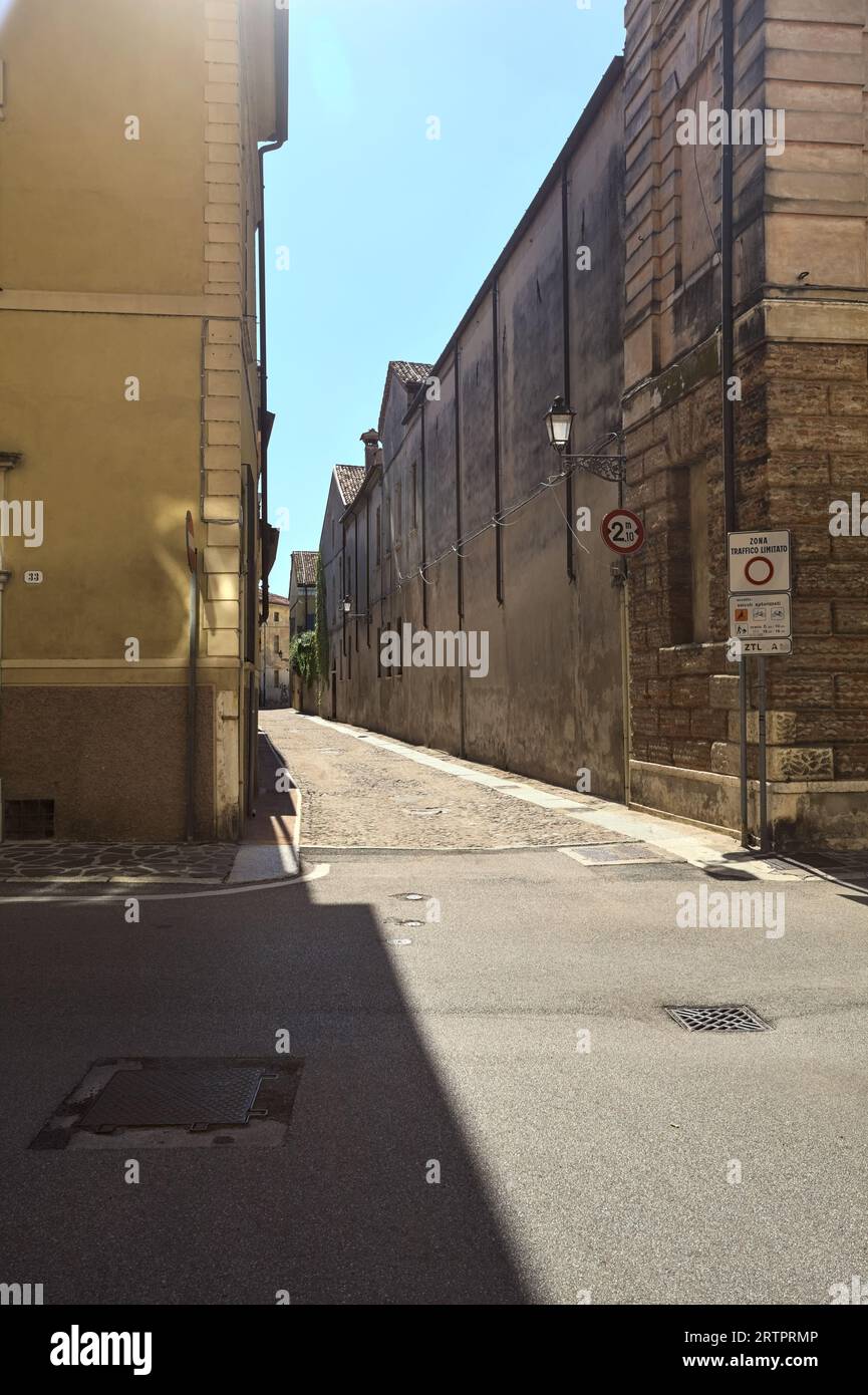Access to an alley seen from a street on a sunny day in an italian town ...