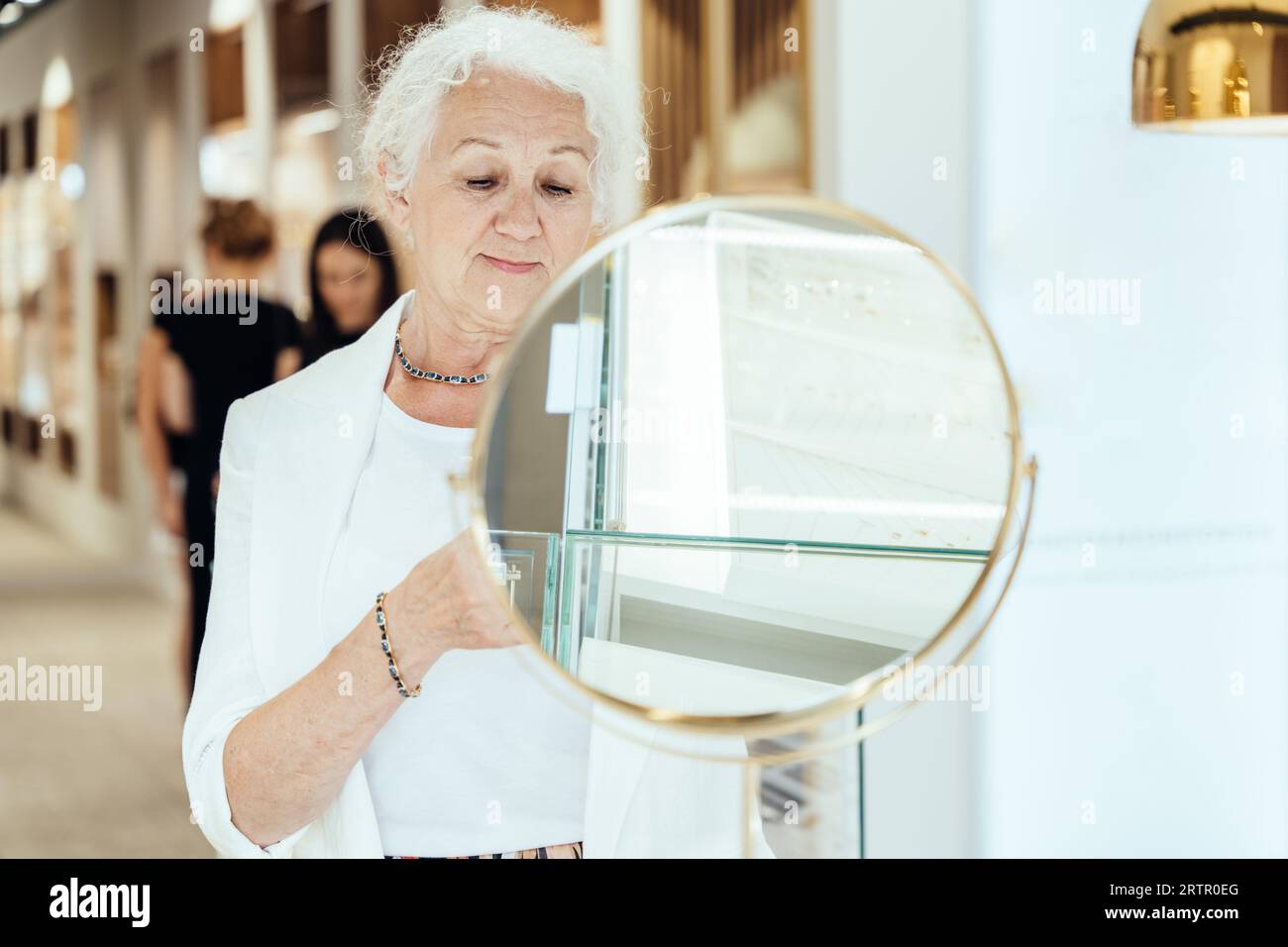 Successful elegant grey haired charming woman wearing white clothes try ...