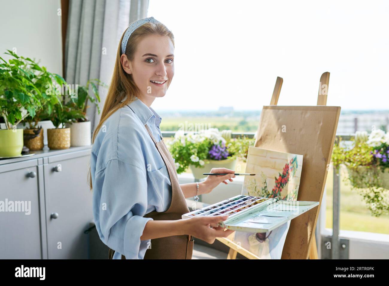 Young teenage female artist painting with watercolors, watercolor ...