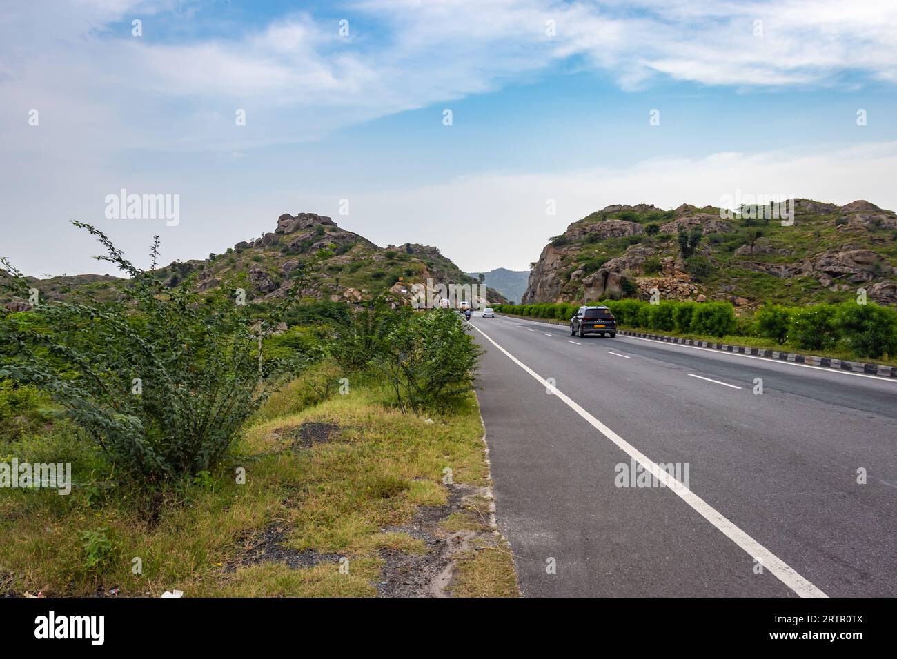 national highway in the middle of mountain range with vehicle passing ...