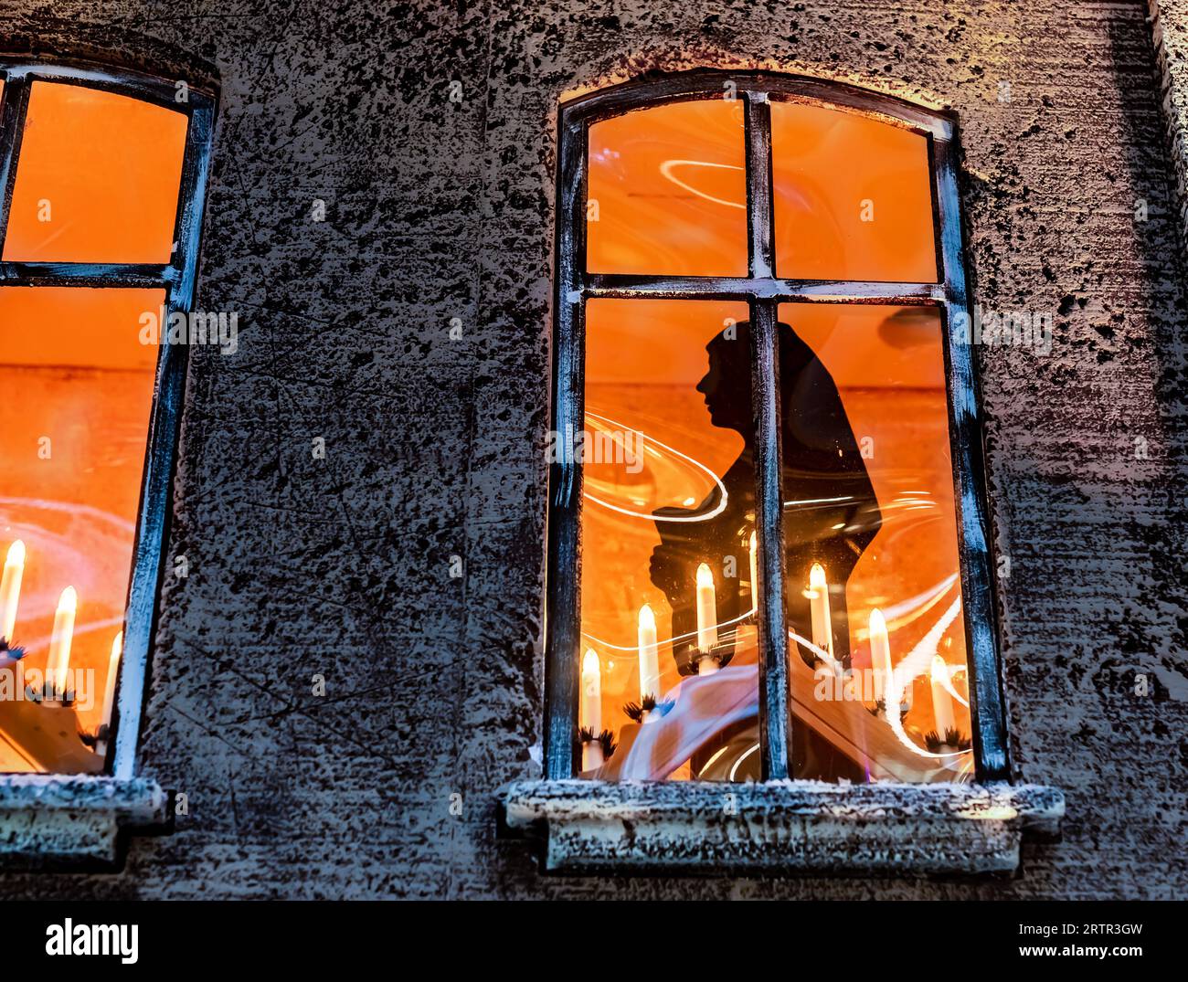 Nun silhouette in window with religious candles for Christmas Stock ...
