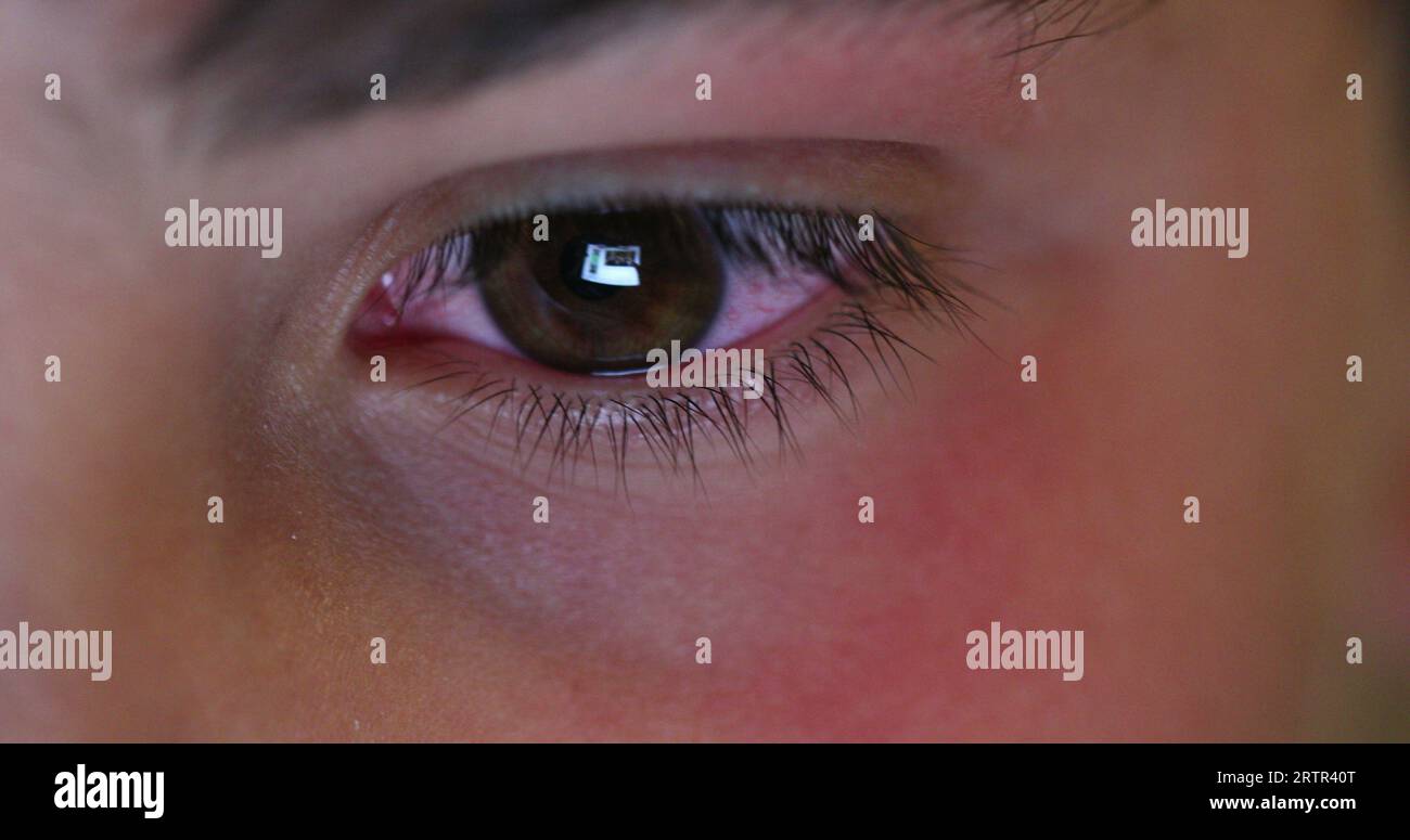 Child eyes looking at device screen. Young boy red eye staring at blue ...