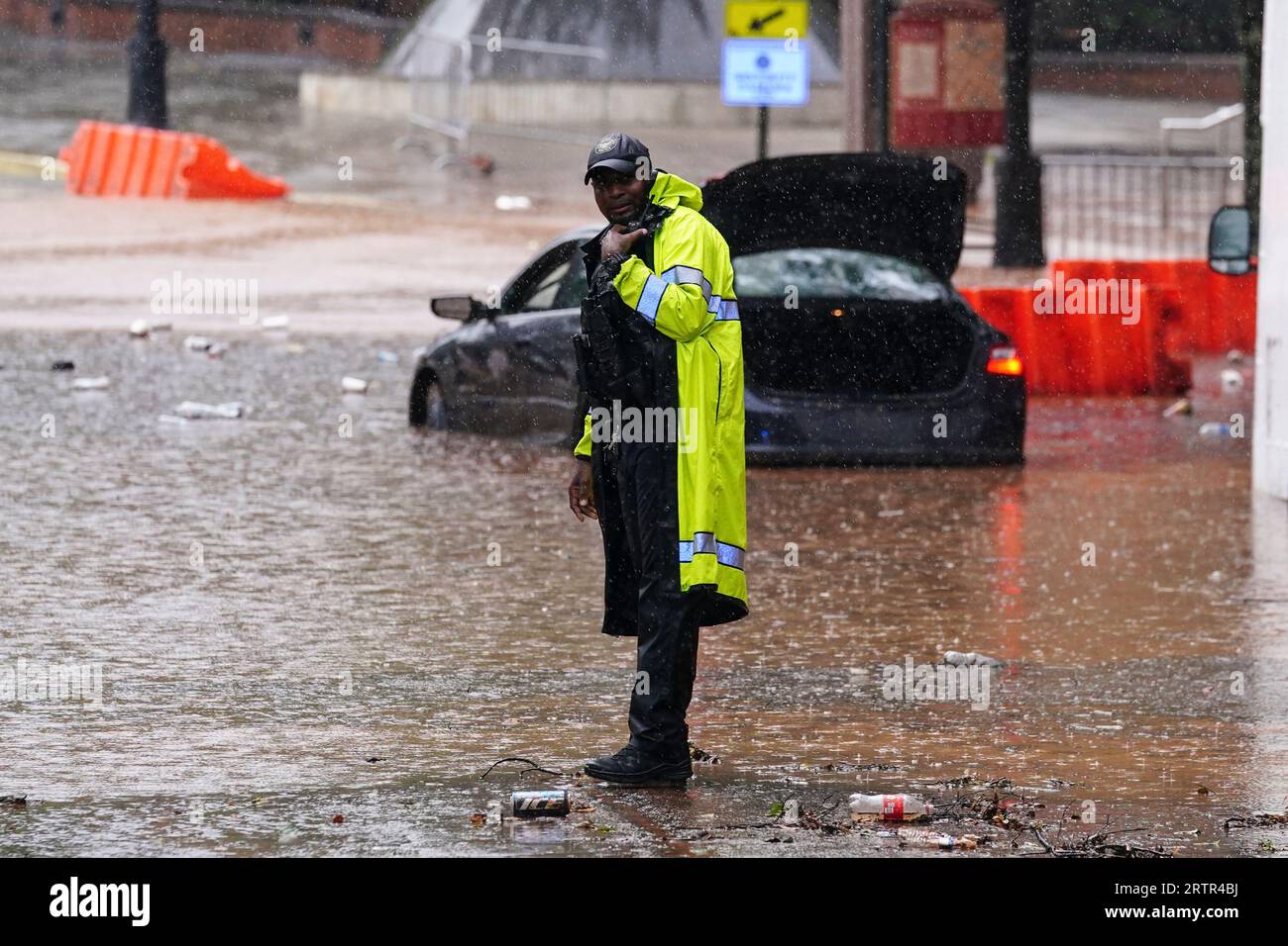 A police officer stands near a flooded car in downtown Atlanta ...