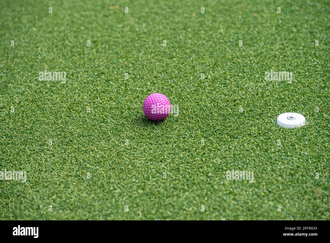 Miniature golf putter by blue ball and hole Stock Photo - Alamy