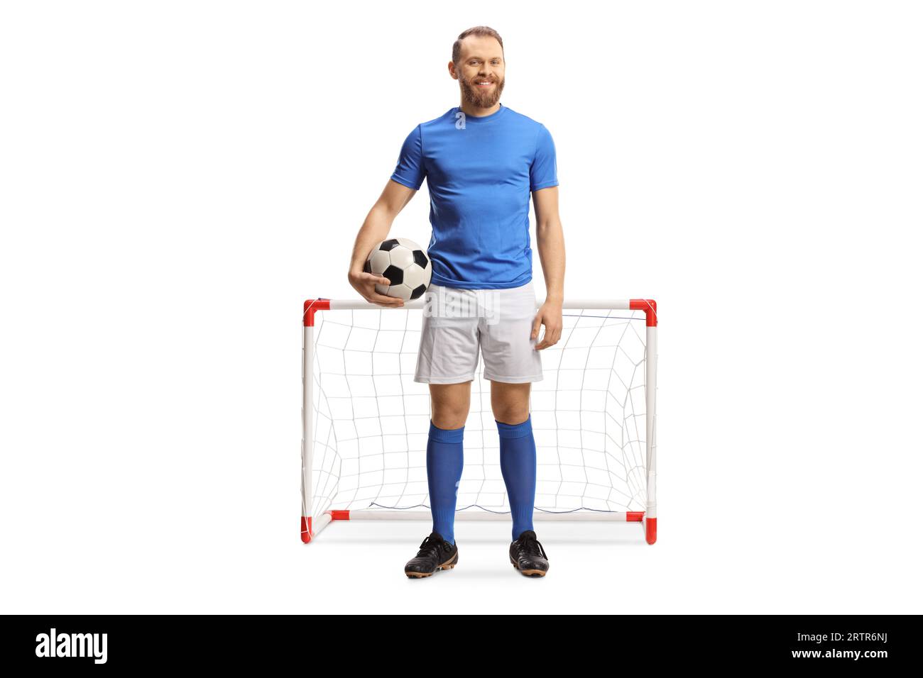 Full length portrait of a footballer holding a ball and standing in ...