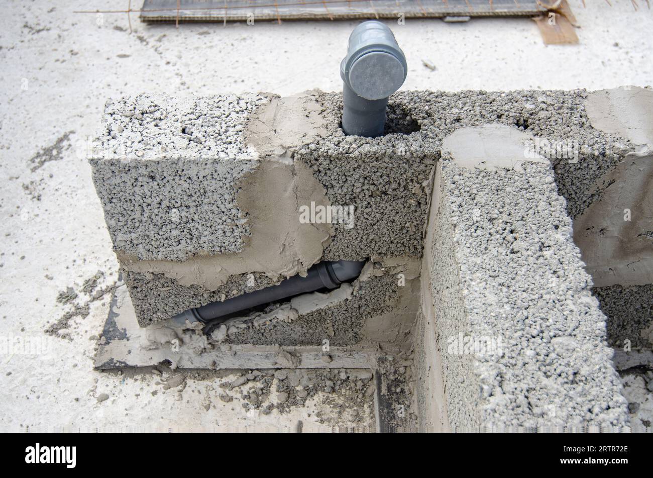 Laying a sewer pipe in the bathroom wall during the construction of a ...