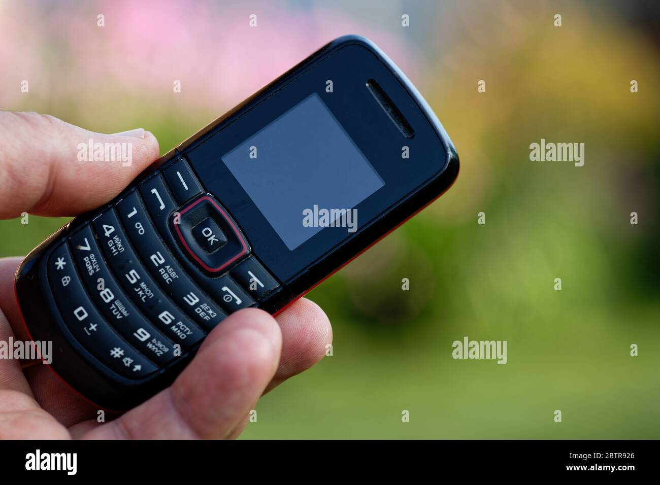 An old push-button cell phone in a hand Stock Photo - Alamy