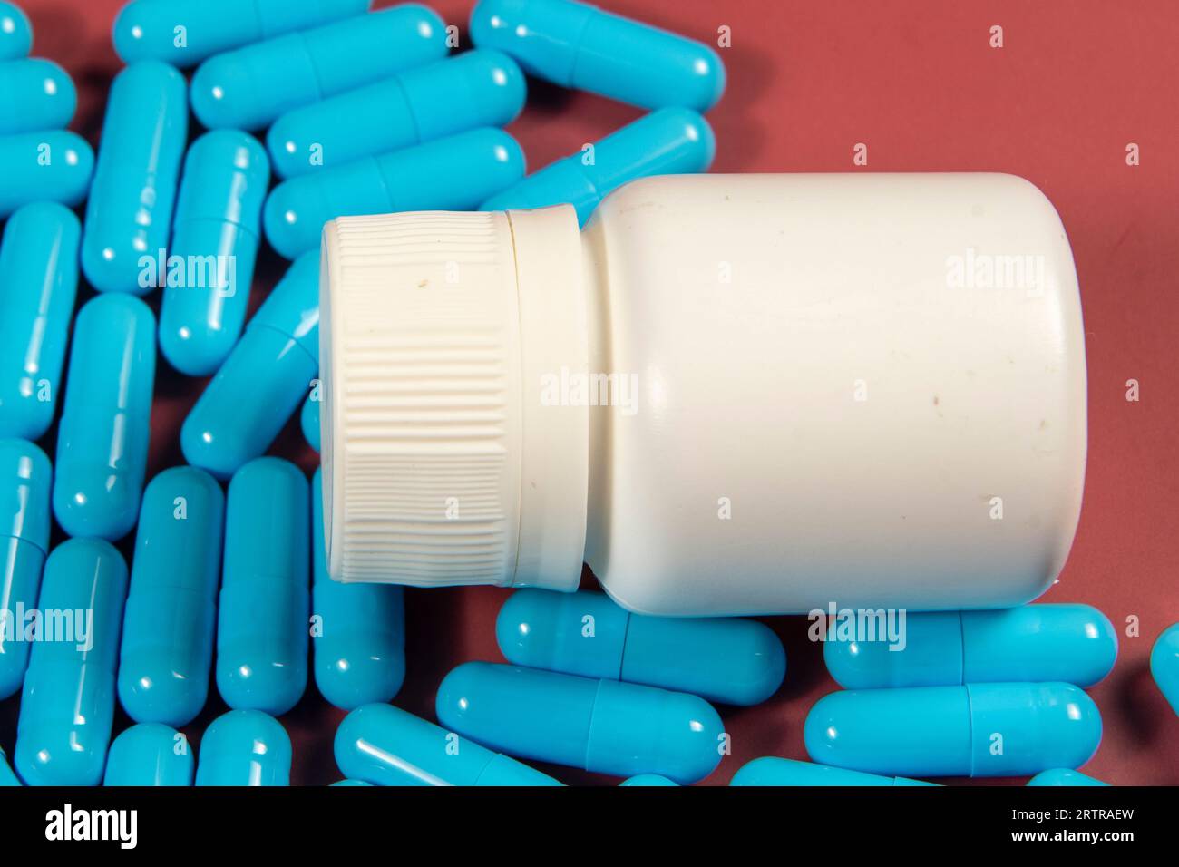 blue medicine capsules and white bottle symbolizing medicine Stock ...