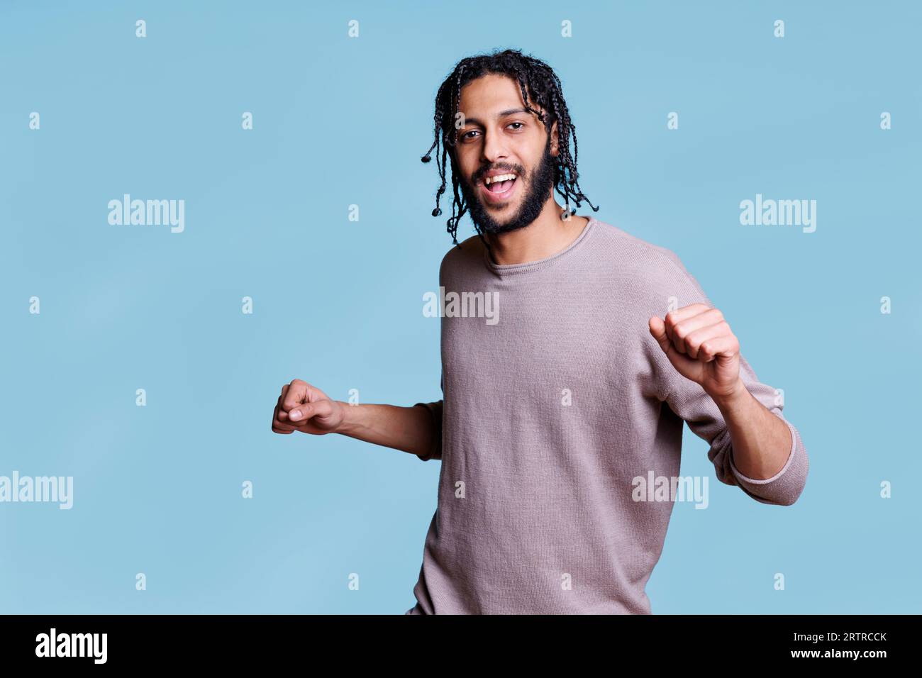Cheerful arab man dancing, enjoying party while moving body and hands ...