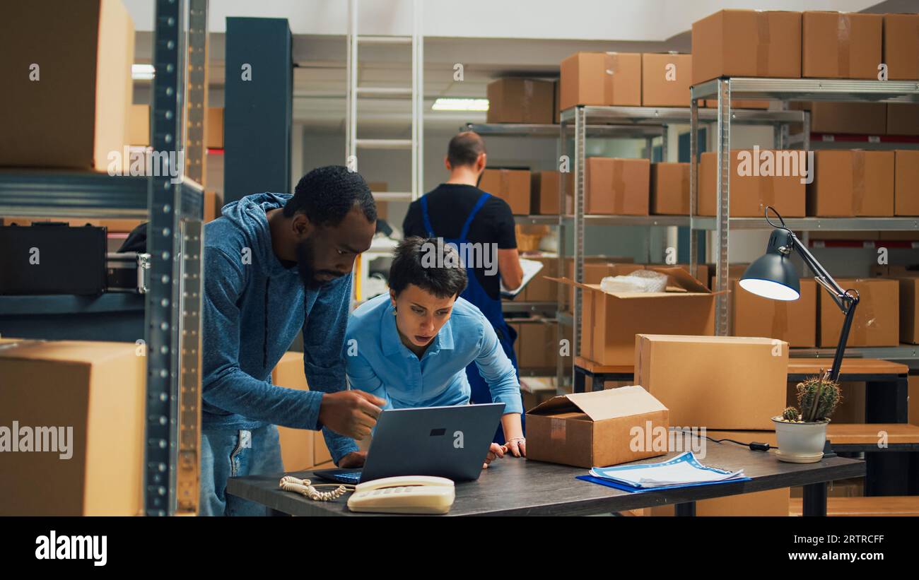 Offce employees doing teamwork to ship goods in cardboard boxes ...