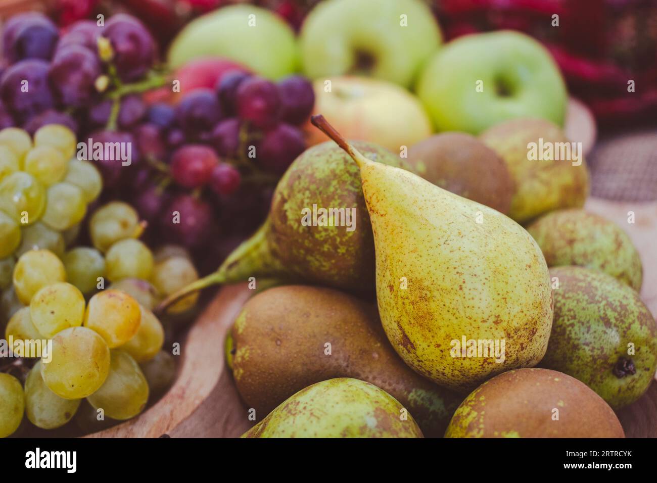 Still life of green pears and green and purple grapes Stock Photo - Alamy