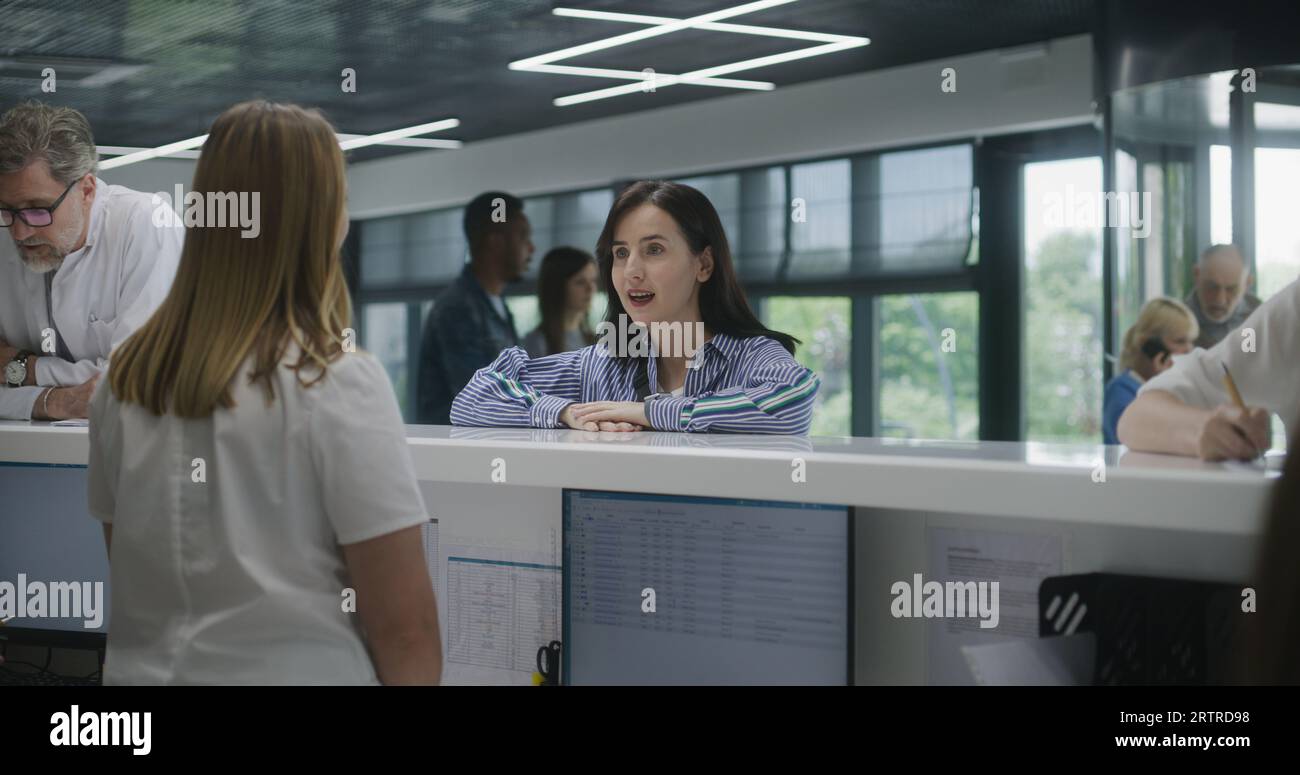 Adult woman stands near reception desk in clinic lobby area and comes ...