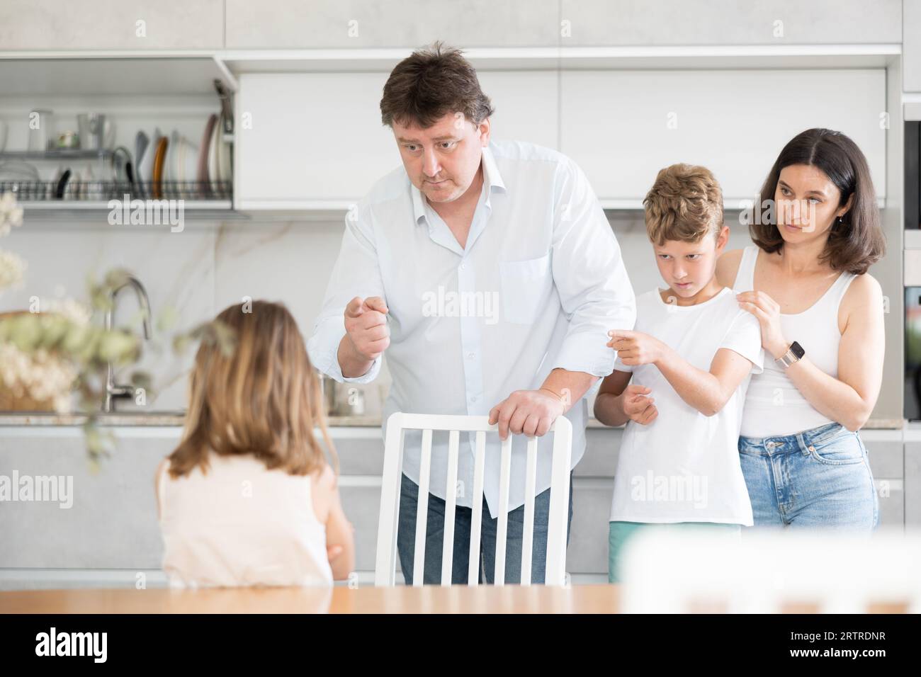 Parents scold their daughter in kitchen at home Stock Photo - Alamy