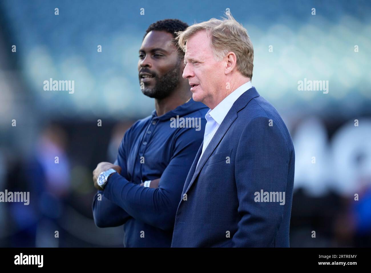 Former NFL football player Michael Vick, left, speaks with NFL ...