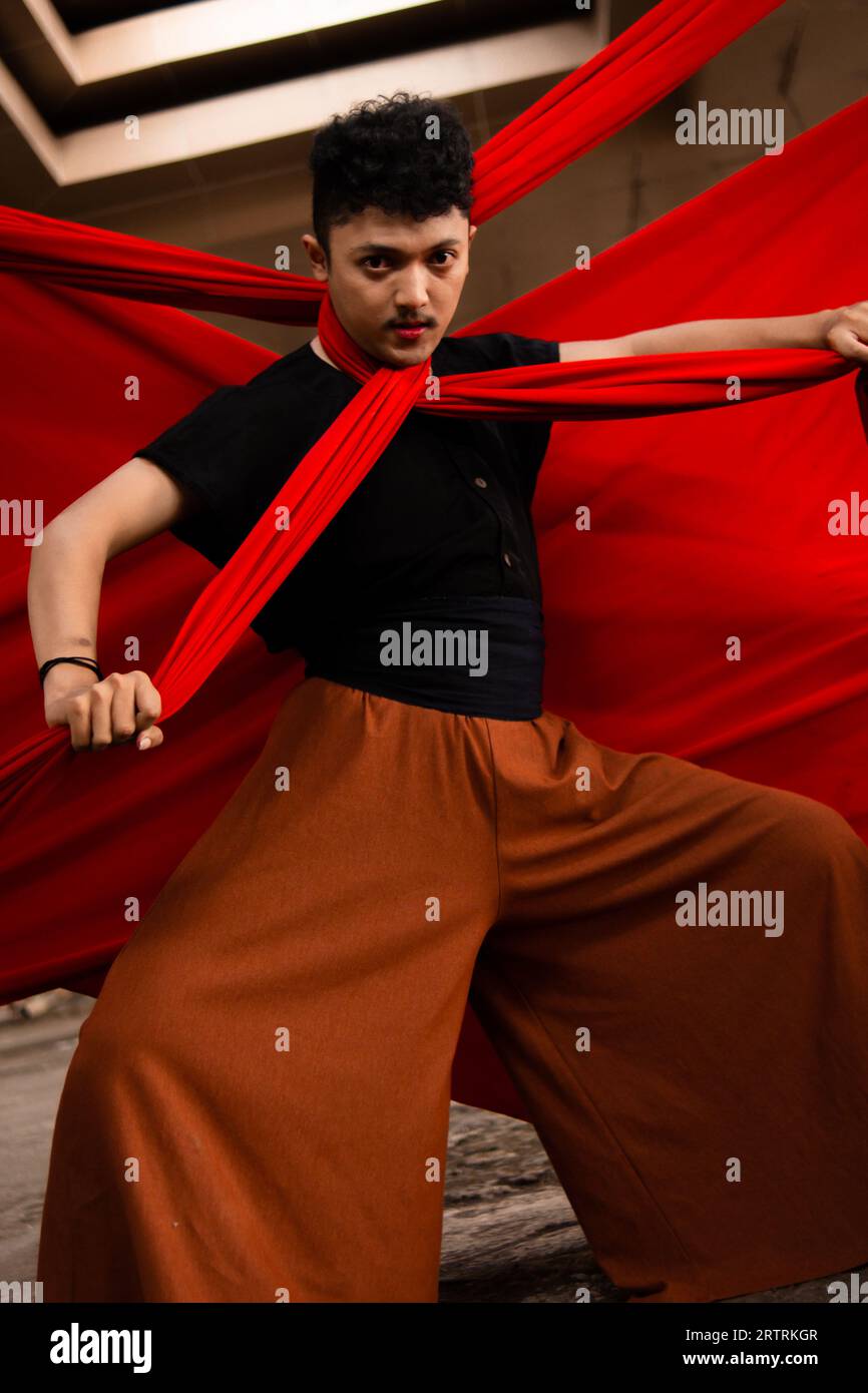 an Asian man in a black shirt is strangled with a red cloth while ...