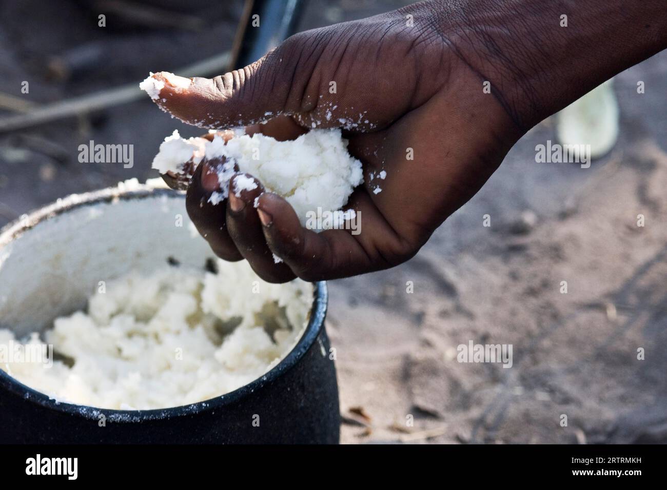 Maize porridge in the hand at the pot, African food Stock Photo - Alamy