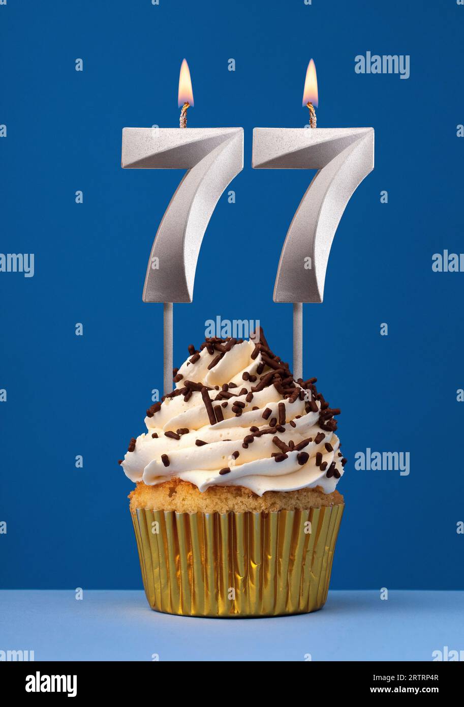 Burning candle number 77 - Birthday card with cake on blue Background ...