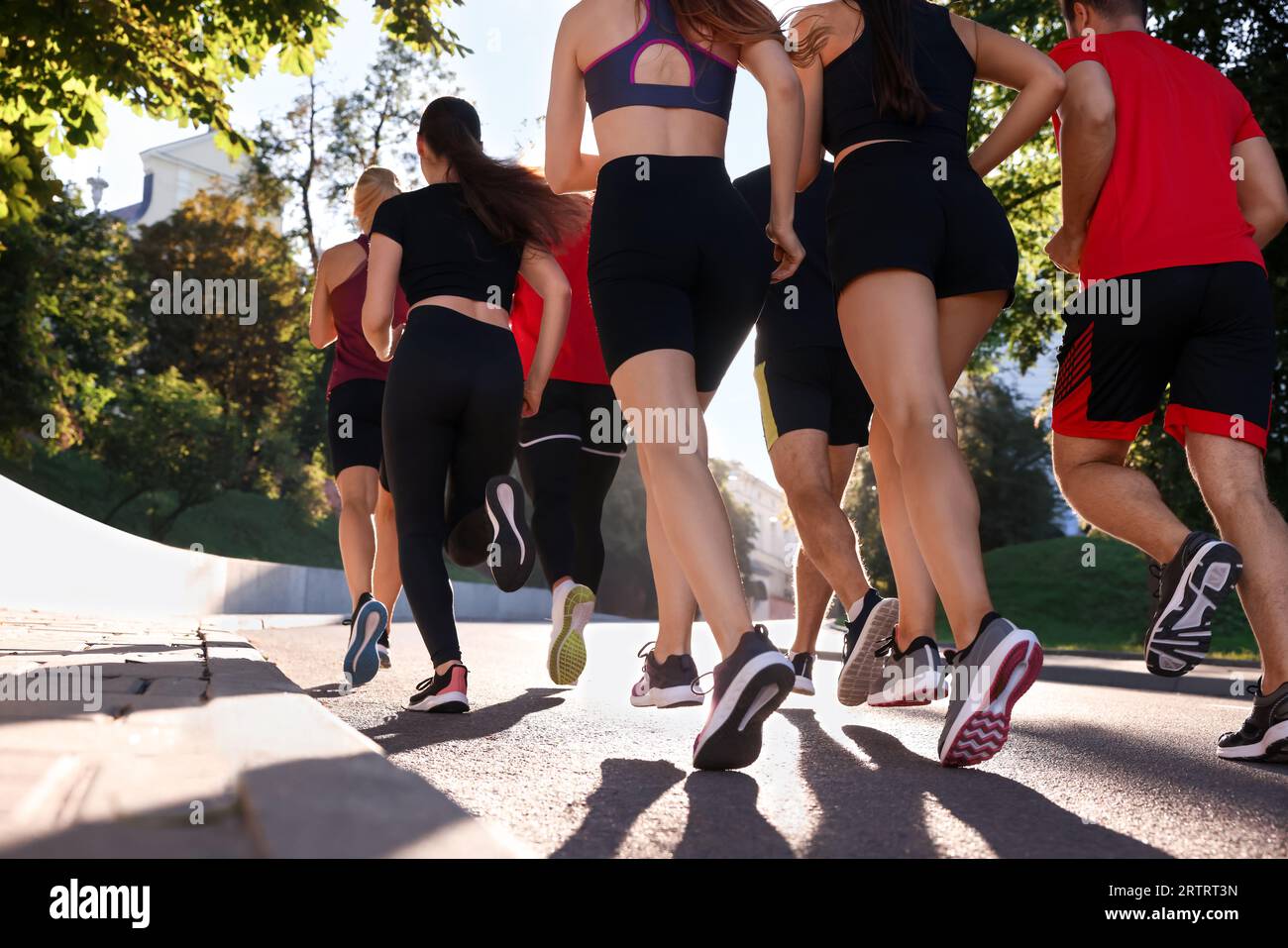 Group of people running outdoors on sunny day, back view Stock Photo ...