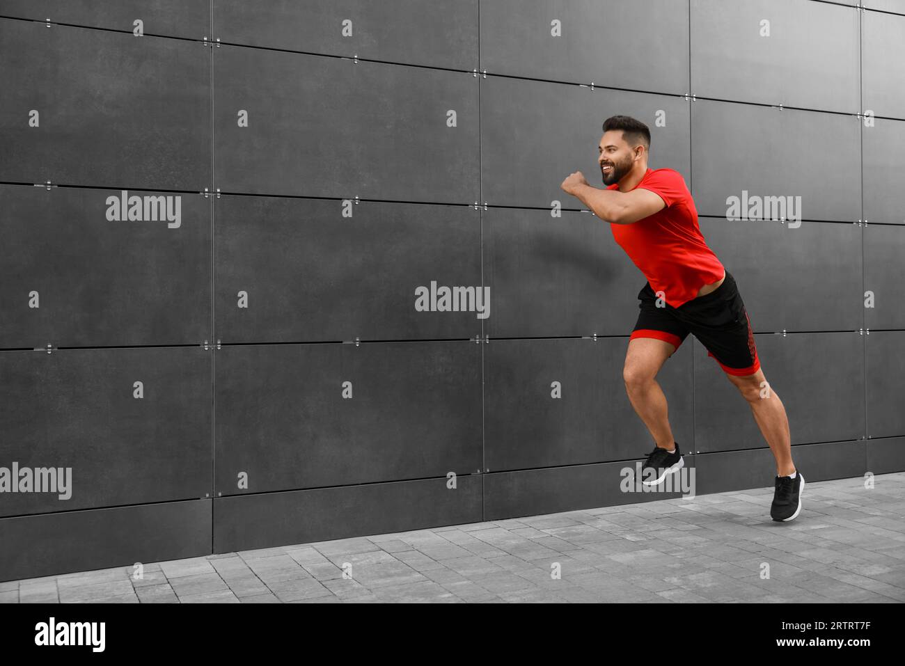 Happy man running near building outdoors. Space for text Stock Photo ...