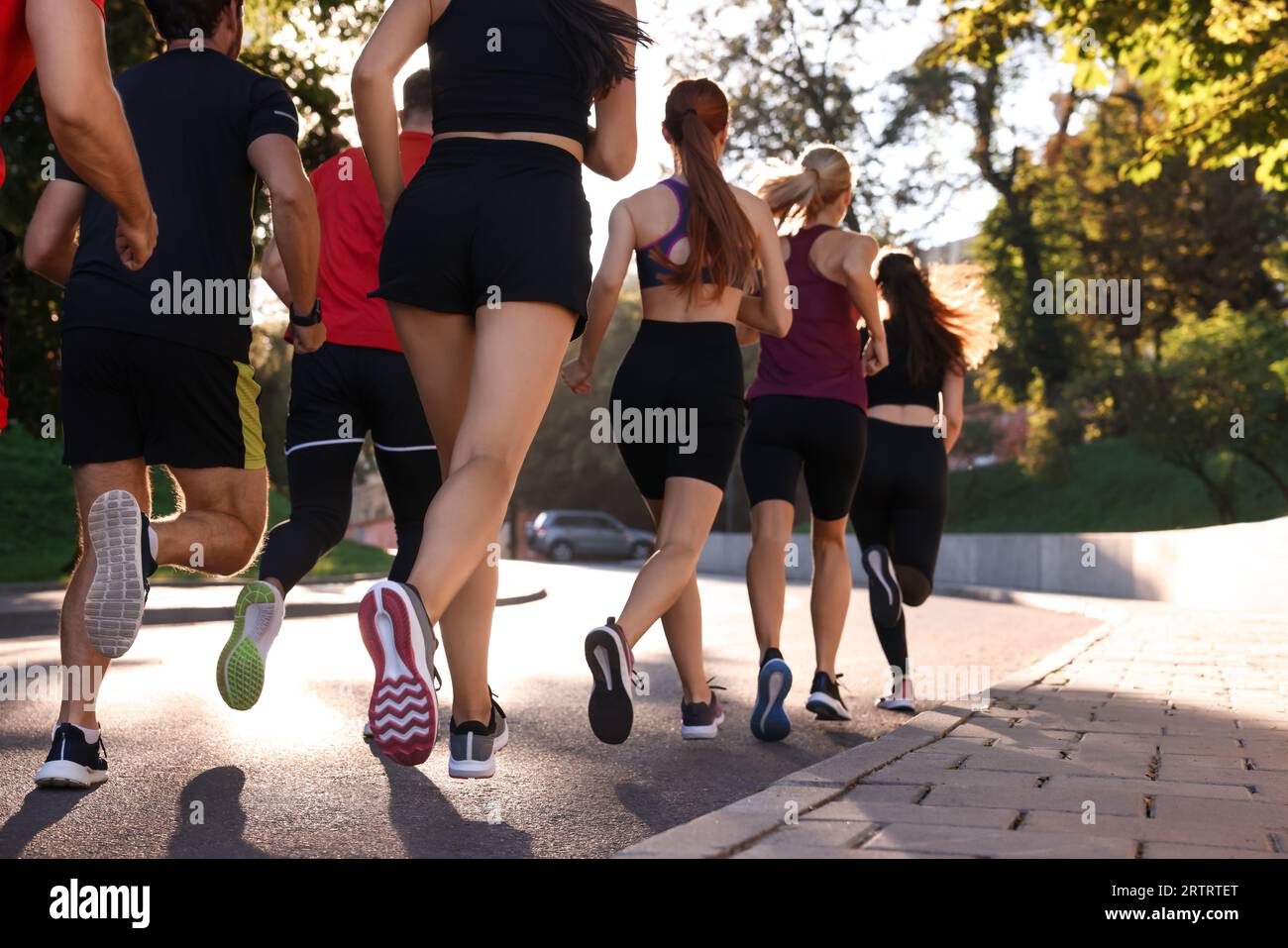 Group of people running outdoors on sunny day, back view Stock Photo ...