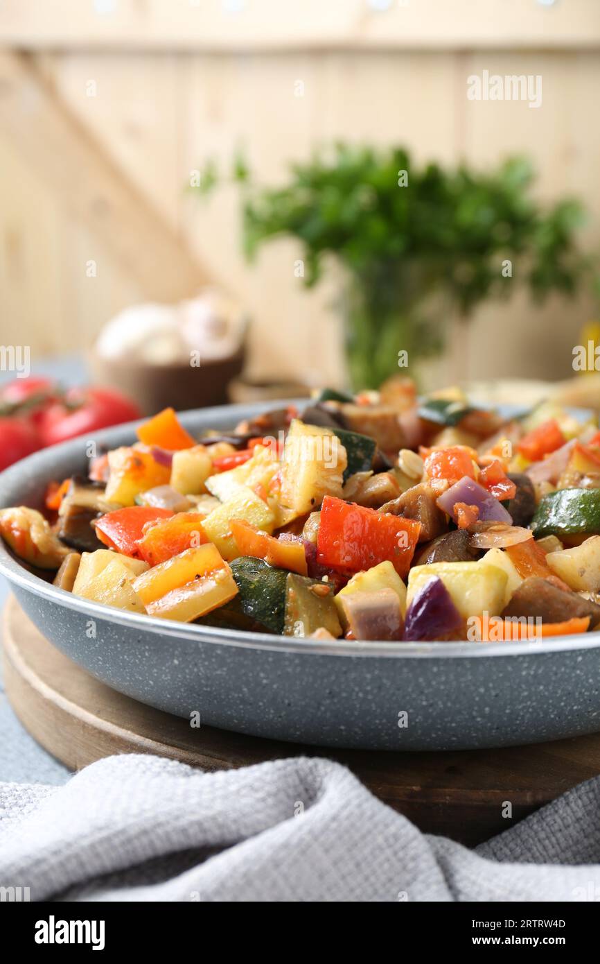 Delicious ratatouille in frying pan on board, closeup. Space for text ...