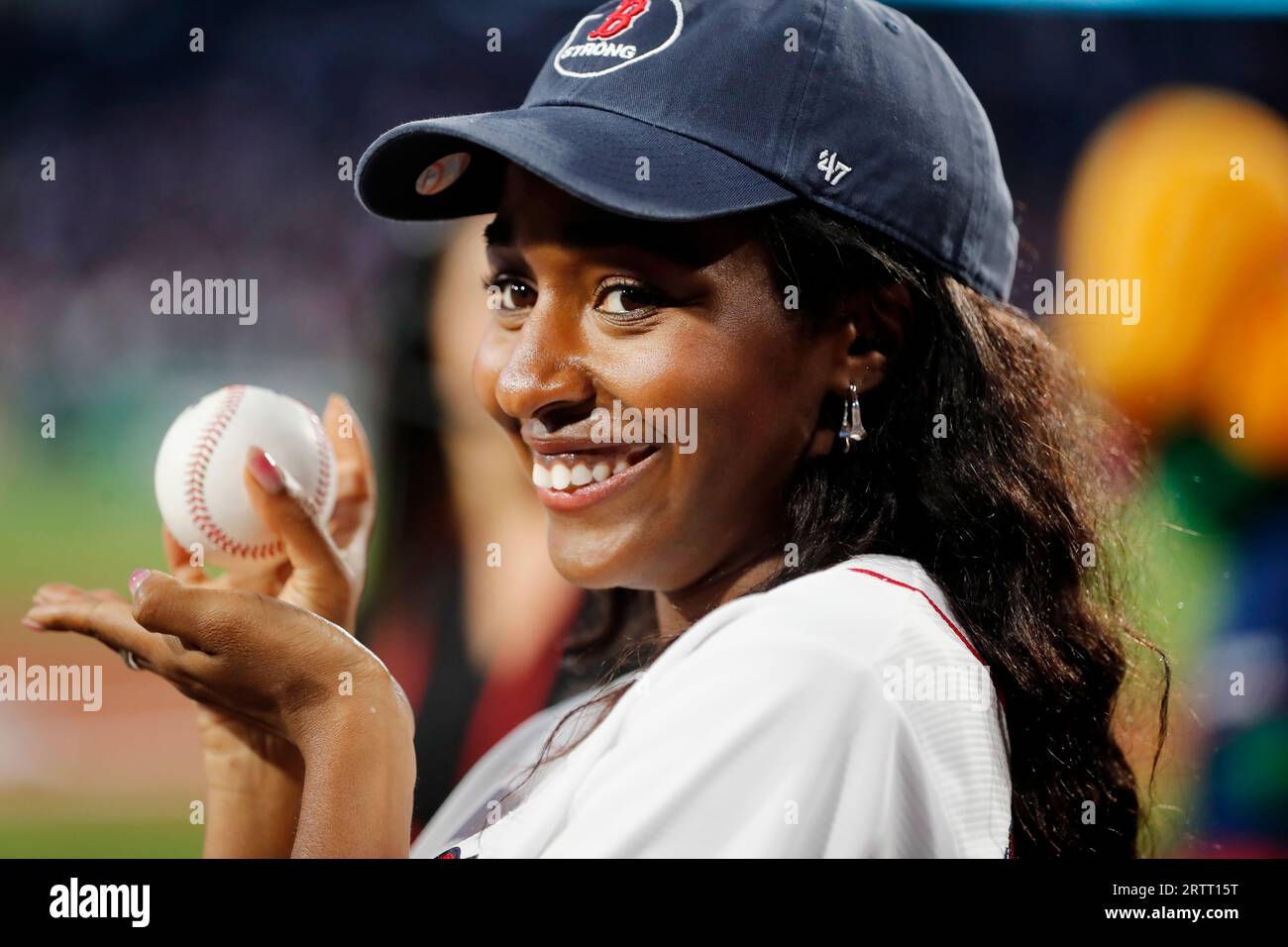 Ayo Edebiri poses with the ball after throwing out the ceremonial first ...