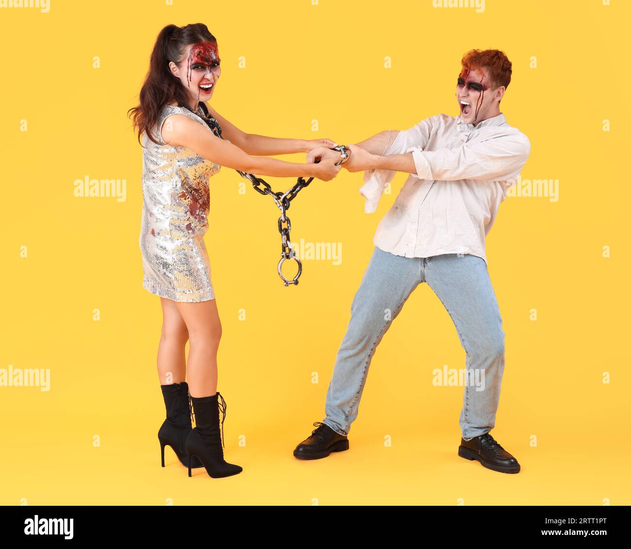 Scary zombies with chains on yellow background Stock Photo - Alamy