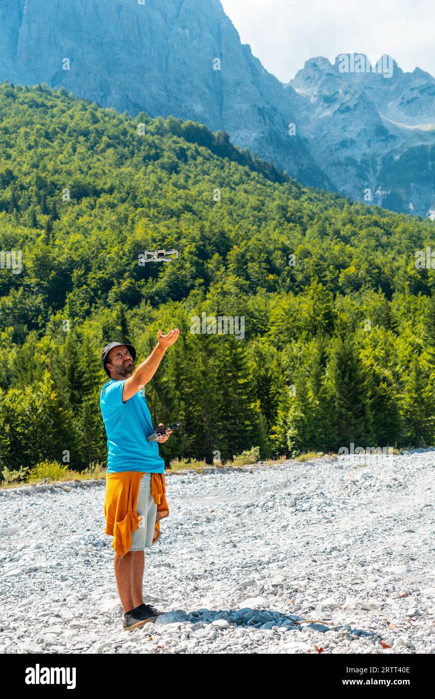 Drone pilot man taking off exploring new places in the mountain. Use of ...