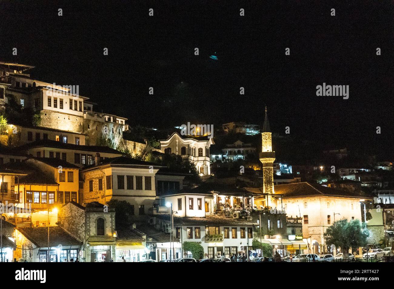 Detail of houses and a mosque in the illuminated historic city of Berat ...