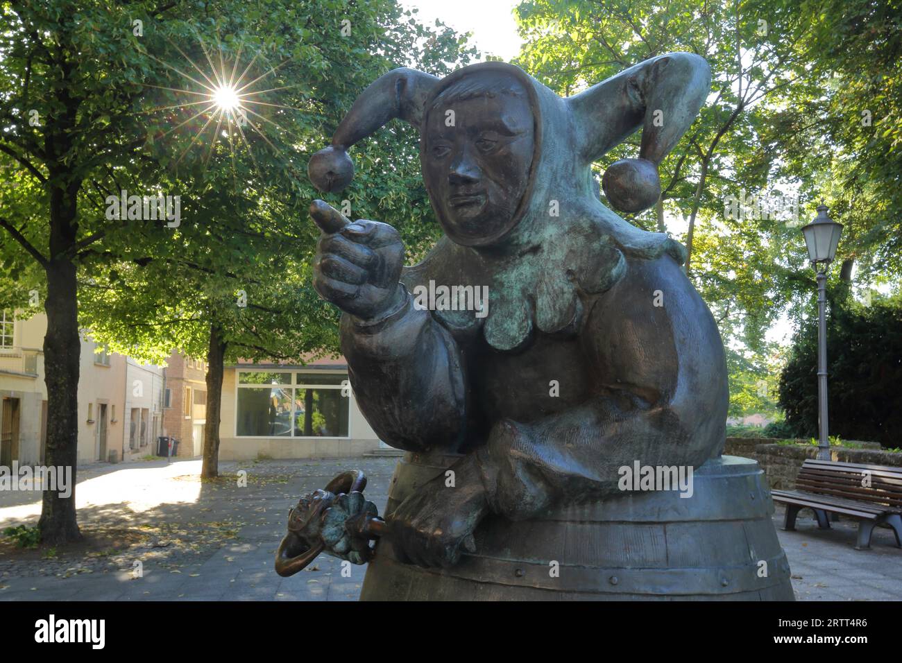 Sculpture Till Eulenspiegel with wine barrel in backlight, jester ...