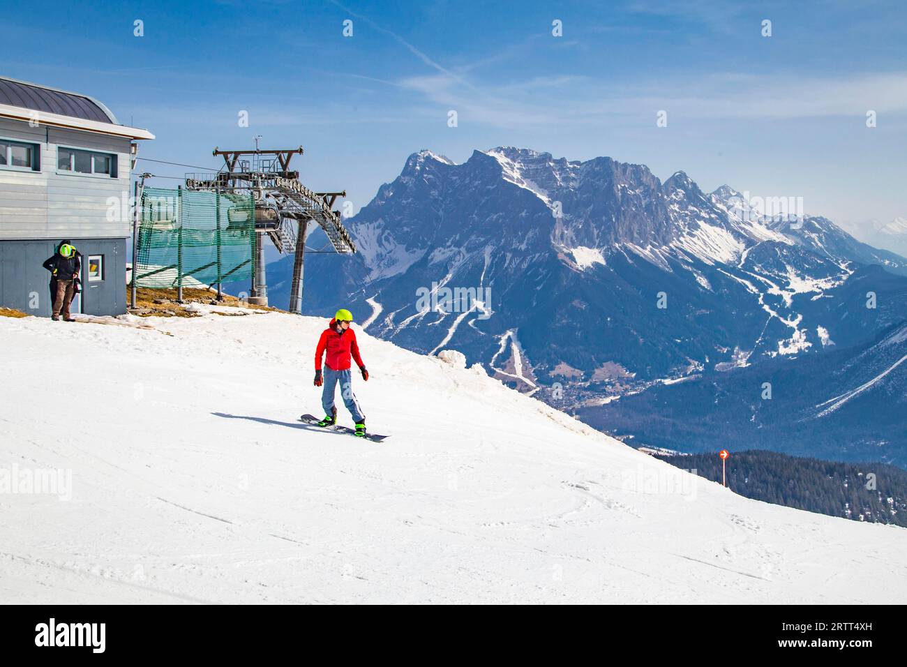 Snowboarder starts on the panoramic run with a view of the Zugspitze, Grubigstein ski area ...
