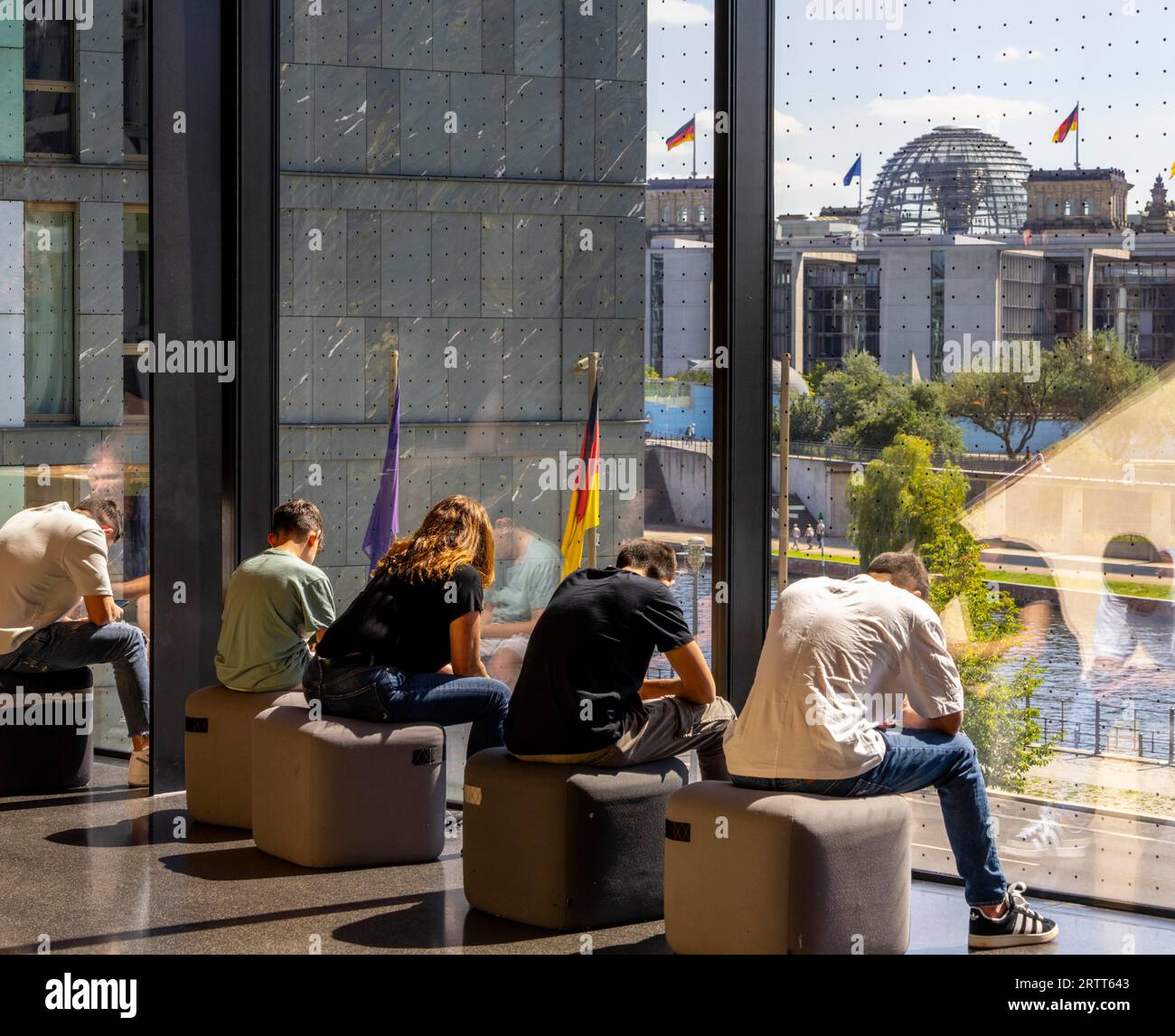 Museum visitors sitting at the window of the Futurium using their ...