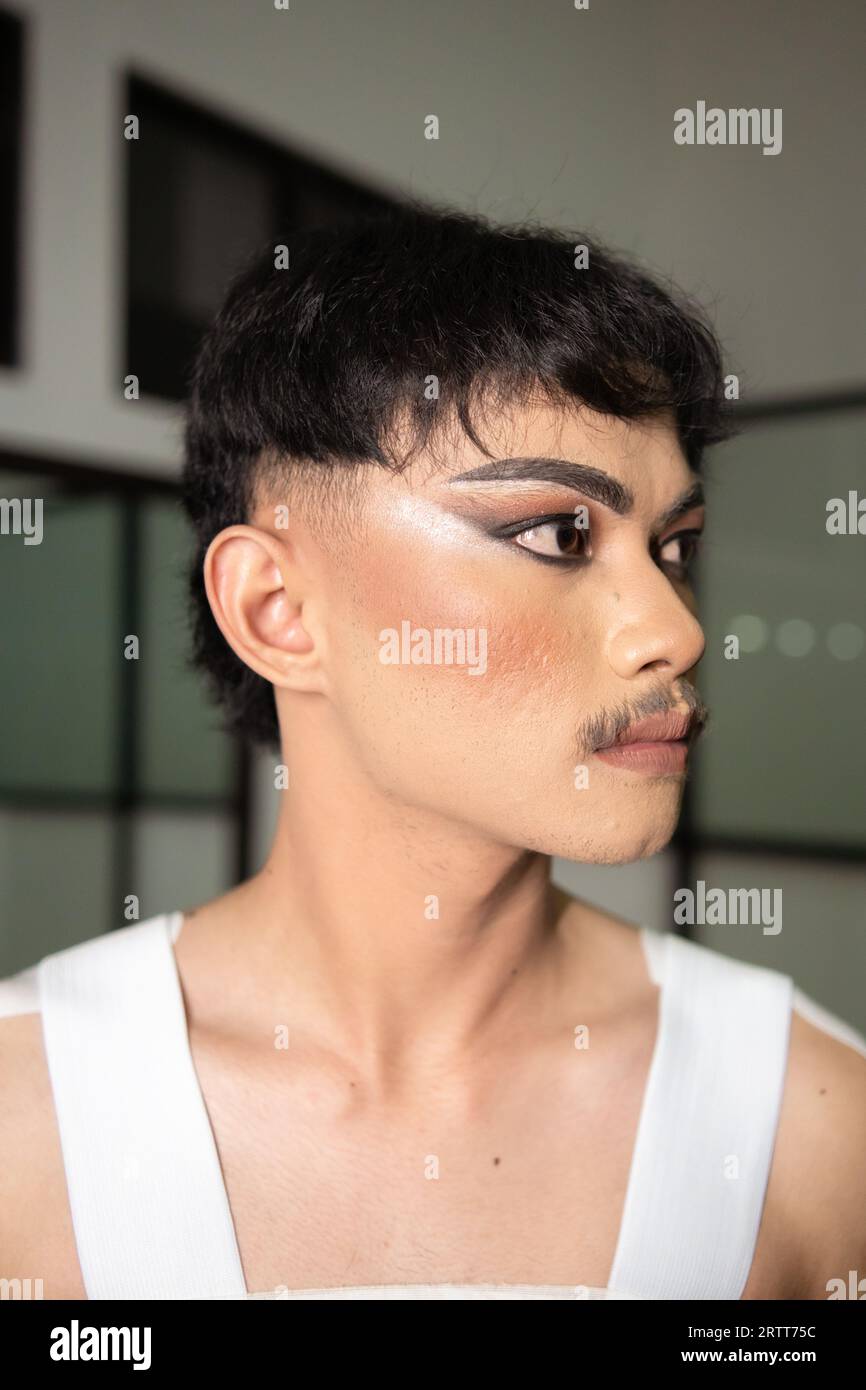 close up face of an Asian man with heavy makeup and dark eyebrows seen ...