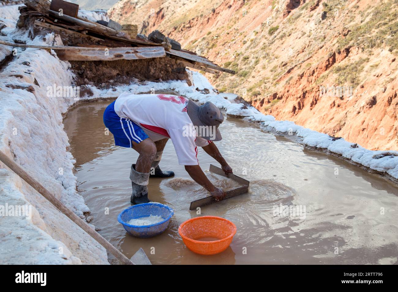 Maras, Peru, October 11, 2015: Man working in a salt evaporation pond ...