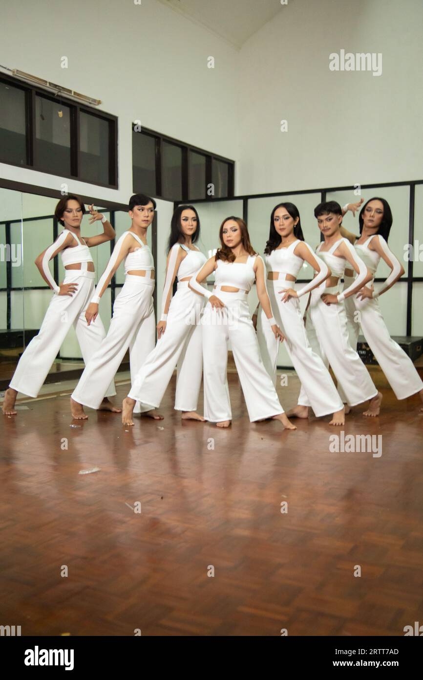 a group of Asian dancers dances with their friends while wearing white ...