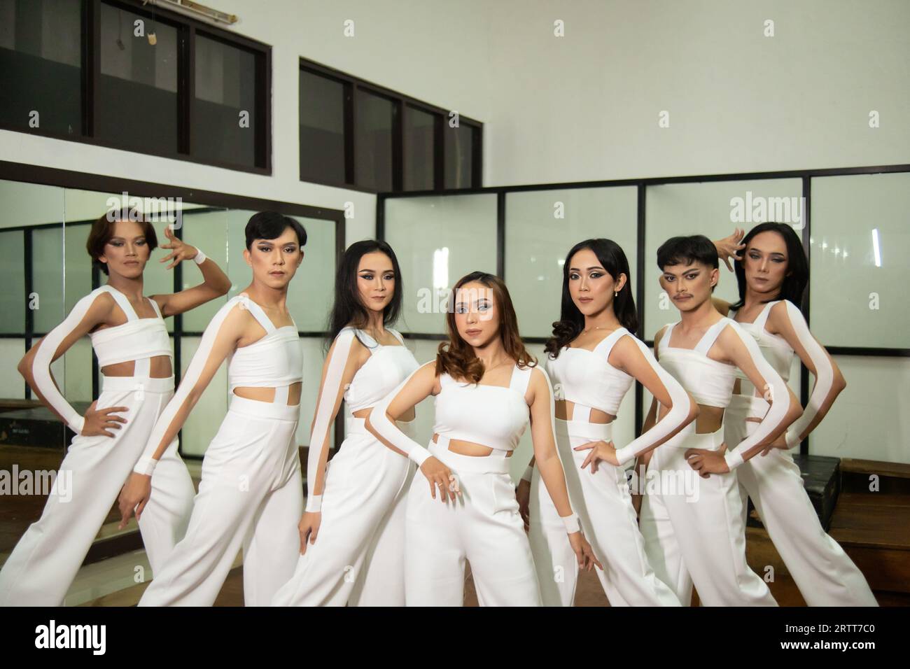 a group of Asian dancers dances with their friends while wearing white ...