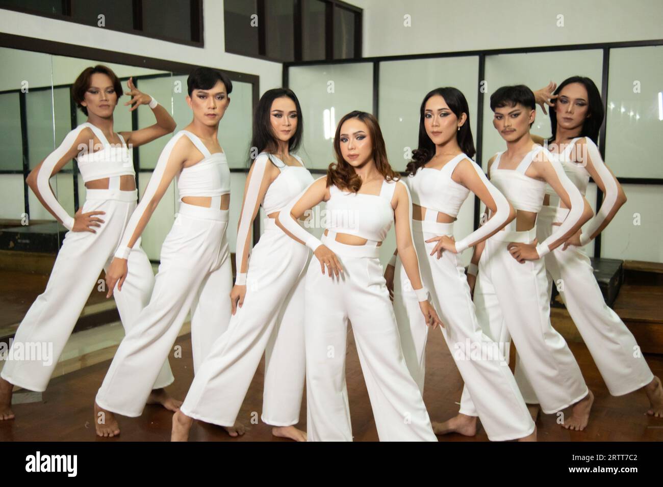 a group of Asian dancers dances with their friends while wearing white ...